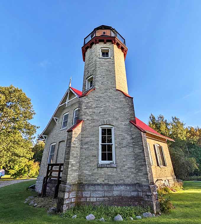 A historic lighthouse with stone walls and red roof details stands as a testament to Mackinaw City's important maritime heritage.