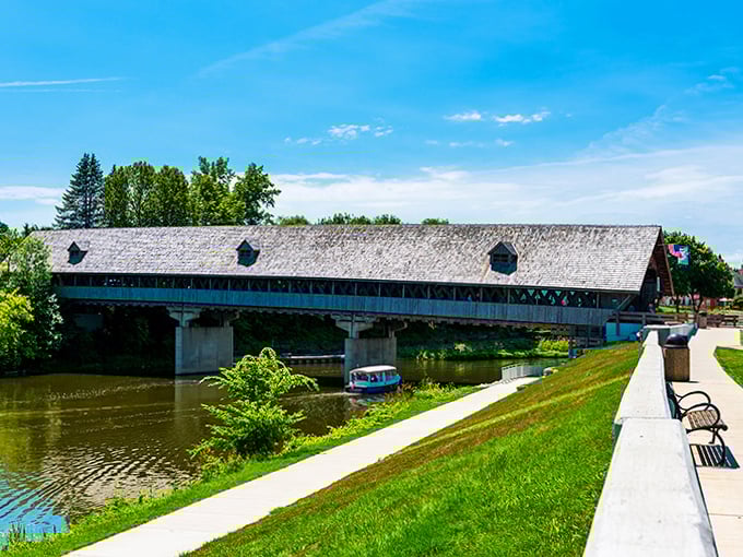From the riverbank perspective, the bridge creates a perfect frame for the gentle Cass River, where occasional boats drift beneath this architectural marvel.