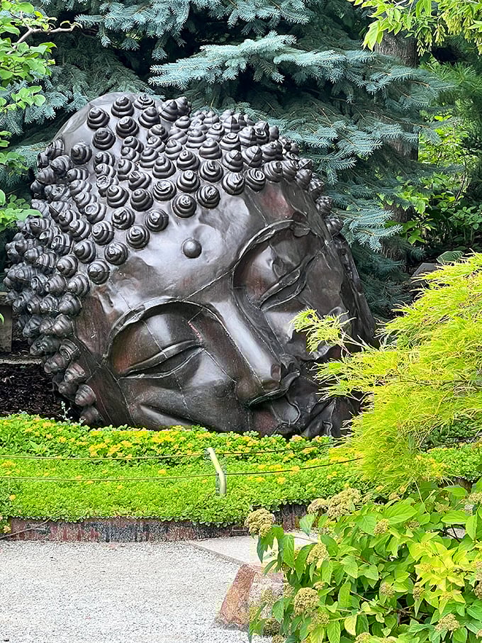 A serene Buddha emerges from the earth like a philosophical jack-in-the-box, offering zen vibes to garden visitors who stumble upon this hidden gem.