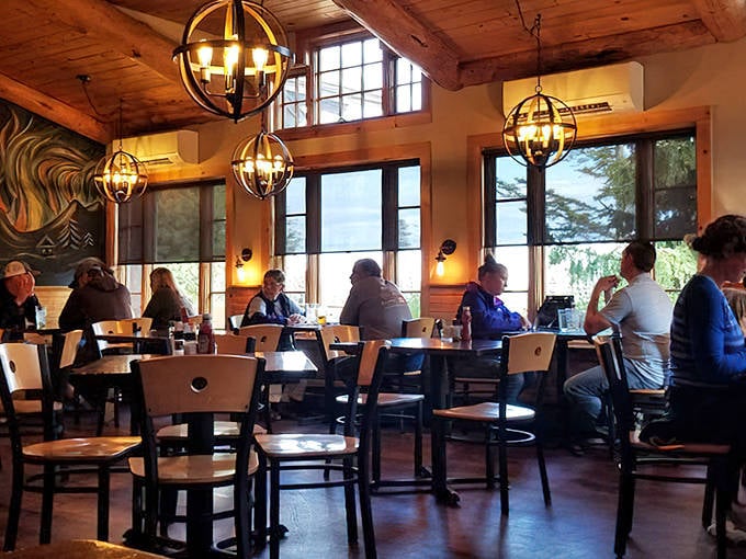 Rustic elegance defines the dining space, where globe pendant lights cast a golden glow over happy diners and wooden tables.