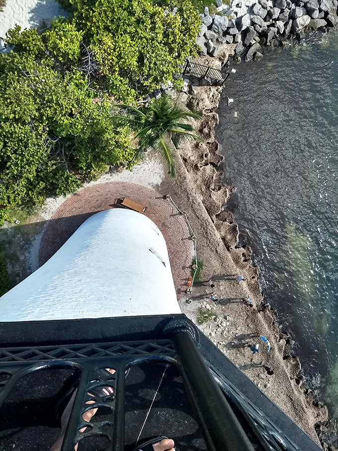 From the top, the lighthouse's shadow stretches across the shoreline like a sundial, marking time against the timeless rhythm of waves.