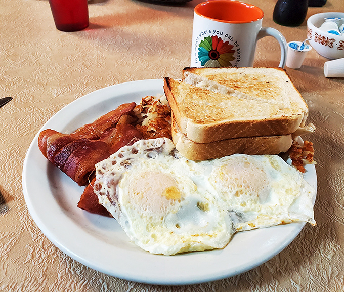 Simple perfection on a plate: golden-edged eggs, bacon with that ideal crisp-chew balance, and toast that's buttered all the way to the edges.