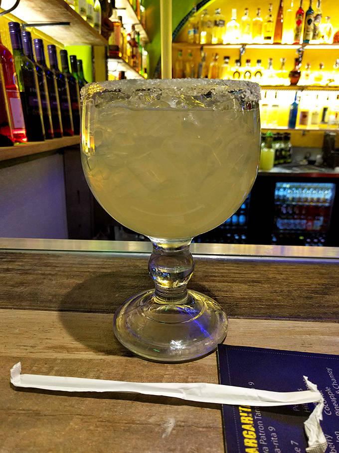 Their margarita arrives in a glass the size of a small fishbowl, perfectly balanced between tequila, lime, and just enough sweetness.