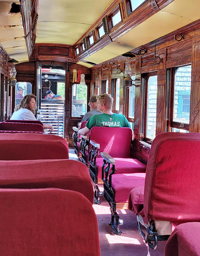 Fellow adventurers settle into the warm embrace of history, the vintage coach's wooden interior glowing with the patina that only decades of use can create.