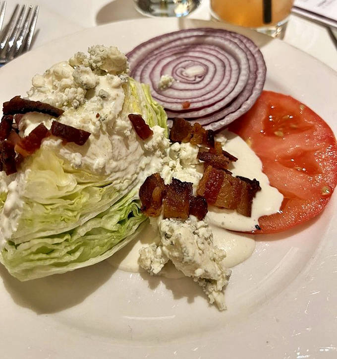The wedge salad &ndash; a monument to simplicity done right, where crisp iceberg meets creamy blue cheese, bacon, and tomato in perfect harmony.