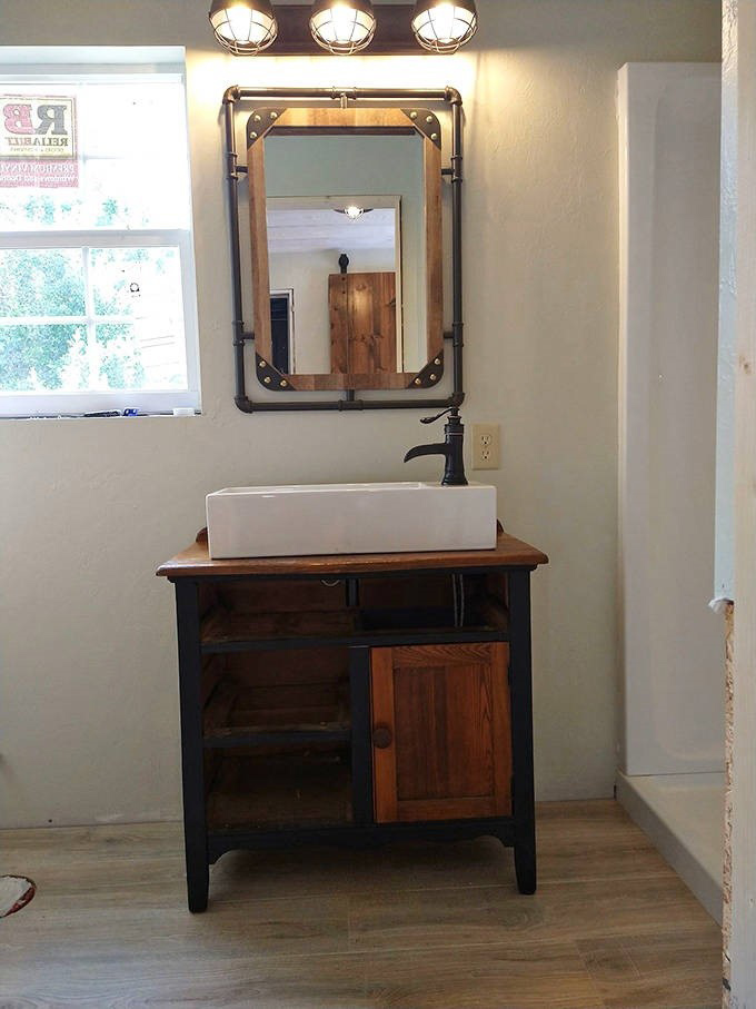 Our vanity features cool industrial piping and a rustic mirror, proving that life on the tracks can be stylish.