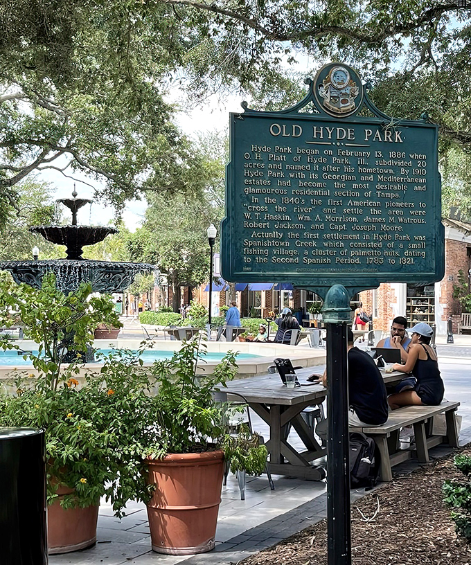 History meets modern life at Old Hyde Park, where a heritage plaque tells tales of yesteryear while today's visitors create new memories at outdoor tables.