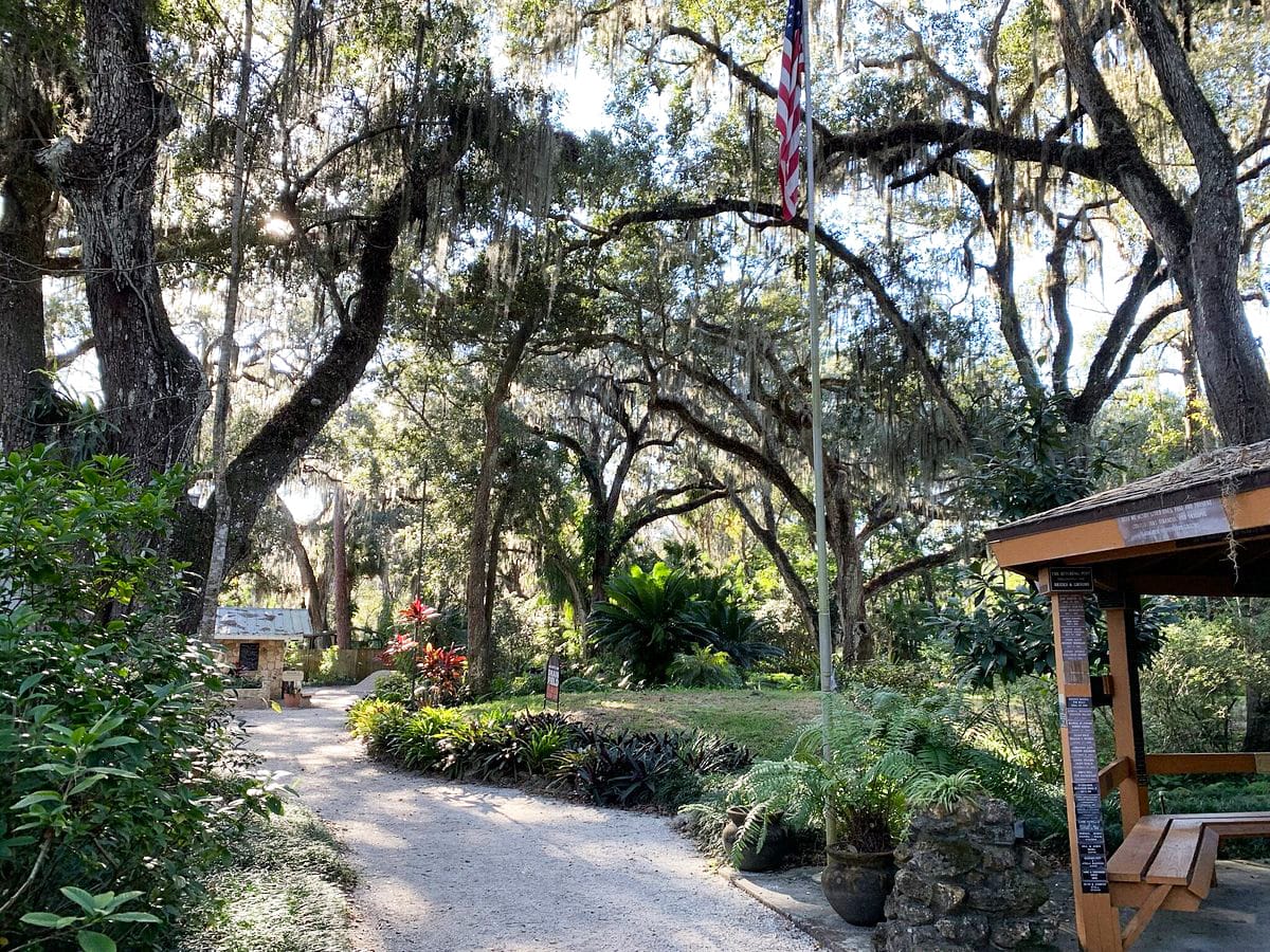 A beautiful trail in the garden surrounded by lush greens and colorful flowers