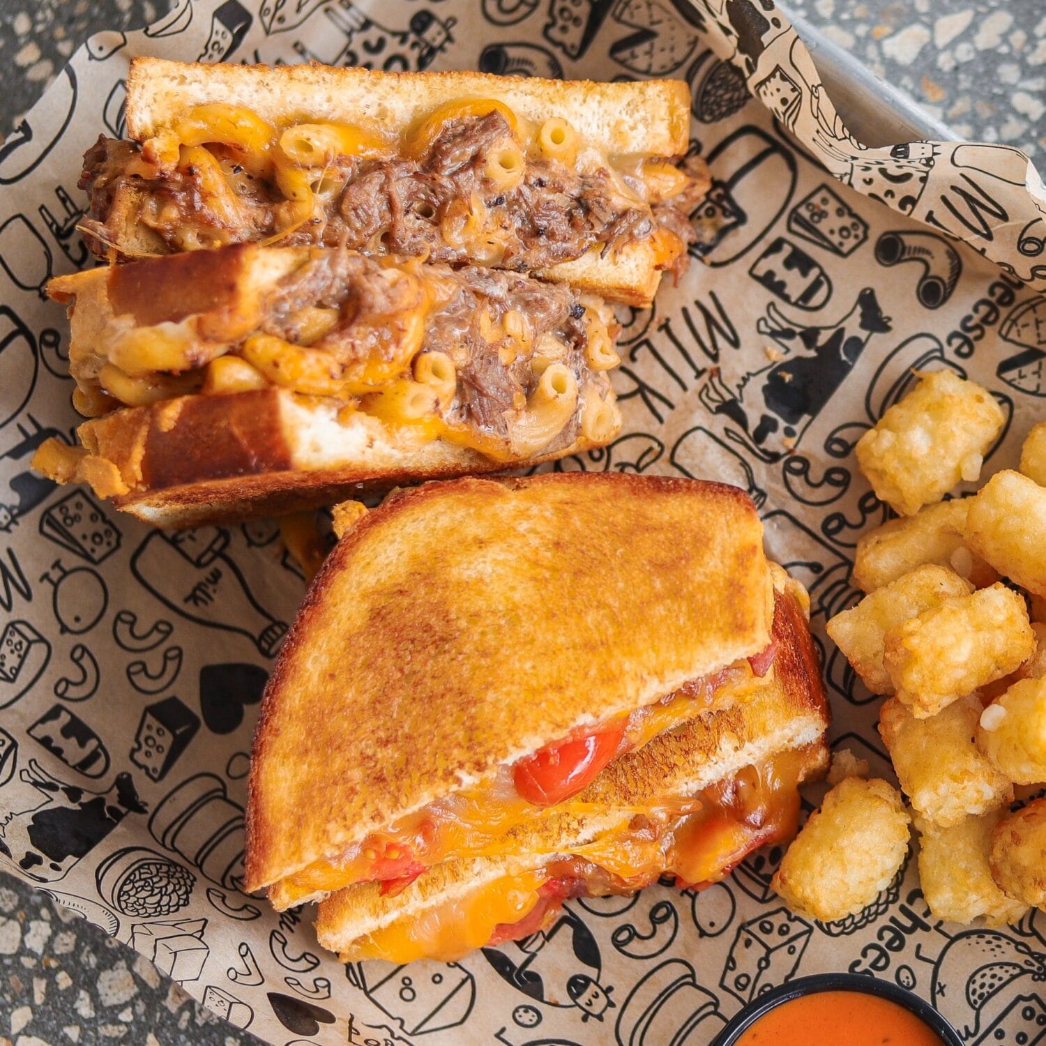 a loaded cheesy sandwich with tater tots on the side