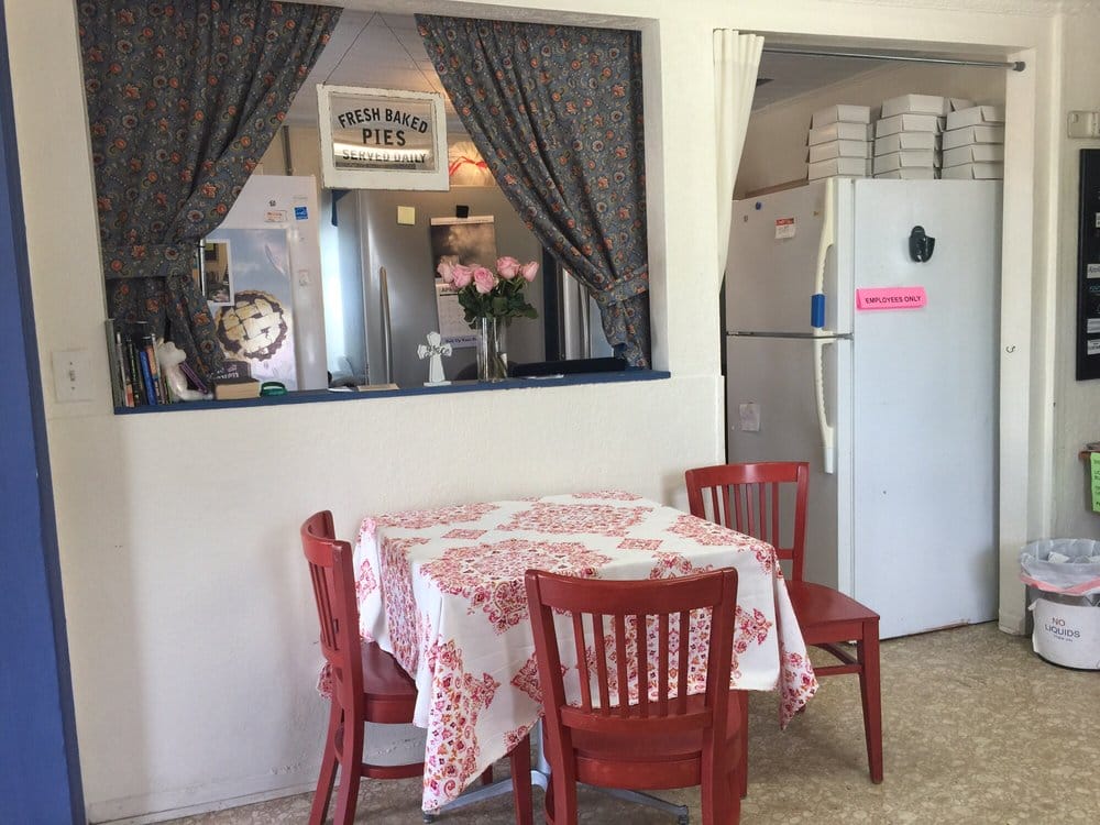 an image of the interior vibe of the cafe with the table and chair placed in front of the serving area