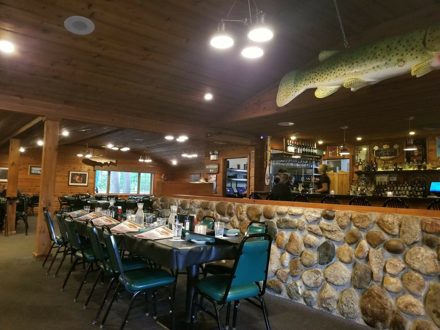 an inviting bar area with stools and a large mounted fish on the wall