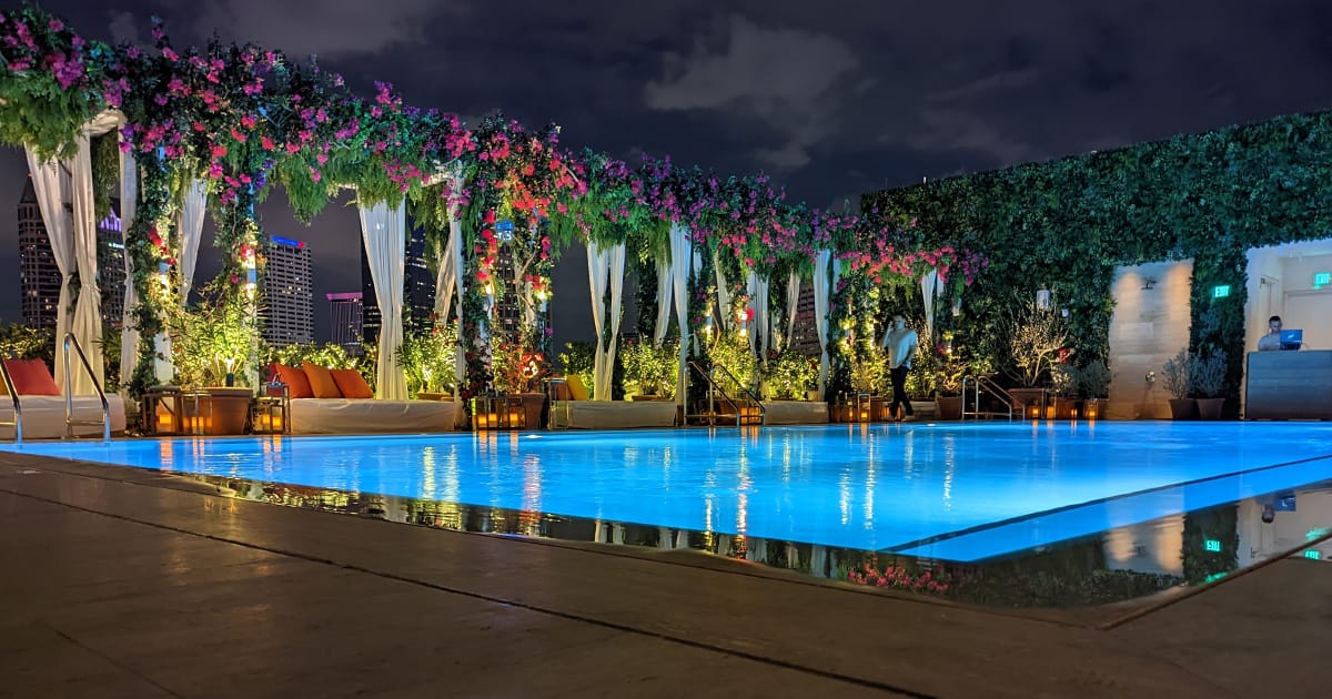 rooftop pool with dj and colorful floral designs on top of the bed chairs