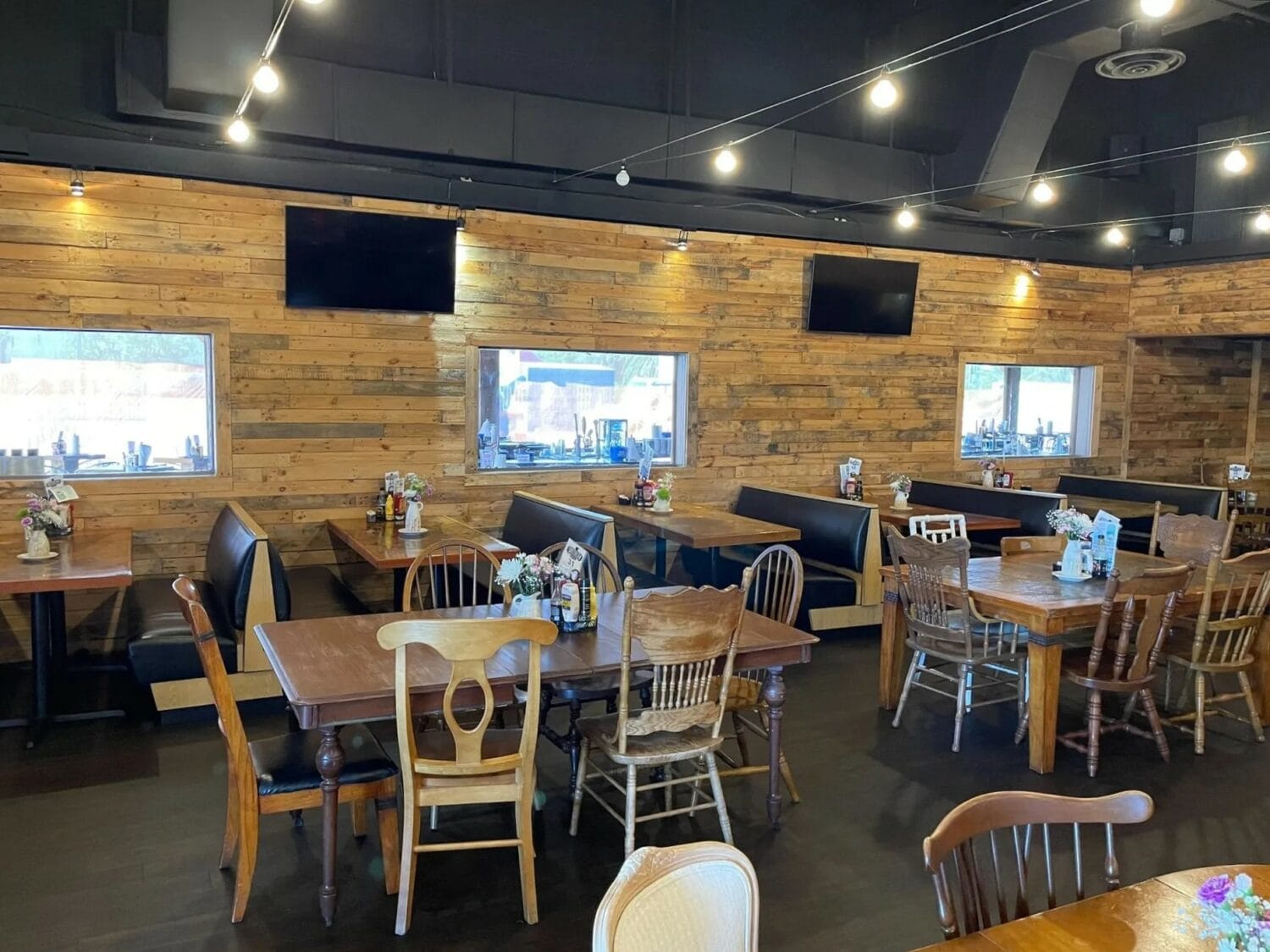 the interior of a cozy restaurant featuring wooden walls and varied seating arrangements with a casual and welcoming ambiance