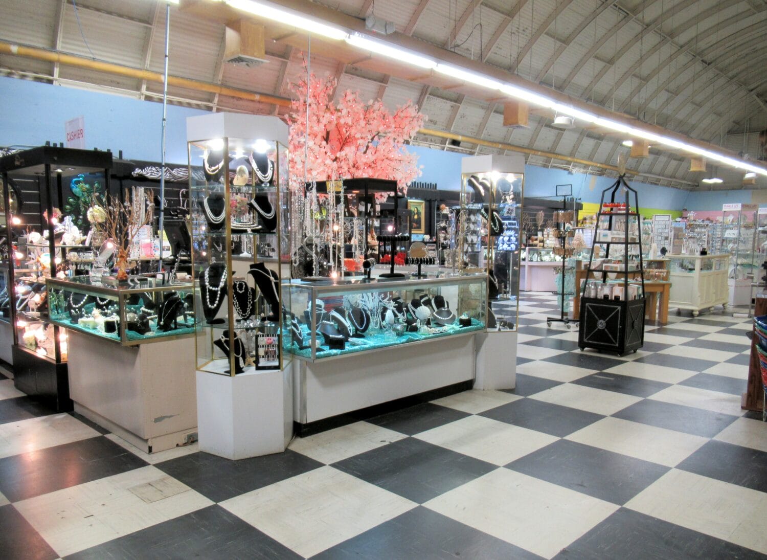 the interior of a retail space with jewelry showcases and brightly lit decorative trees suggesting a shopping area with various merchandise