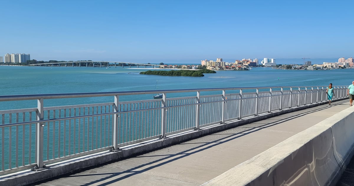 the trail on top of the bridge with views of the water taken from inside a passing car