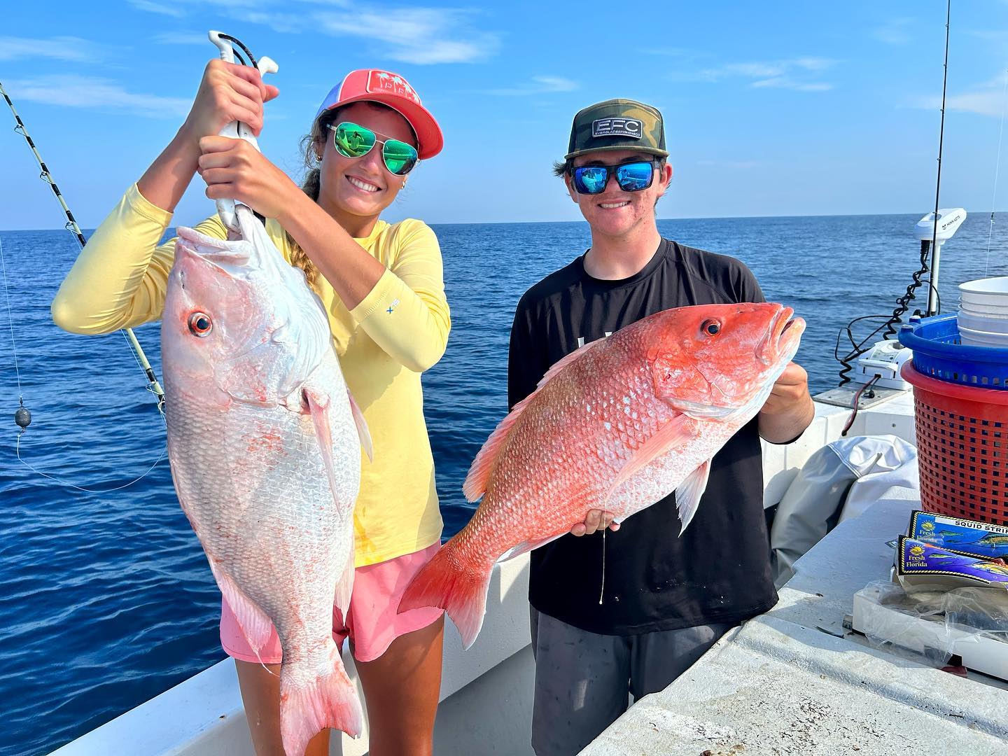 Two individuals showing their catch during a fishing adventure in Keaton Beach