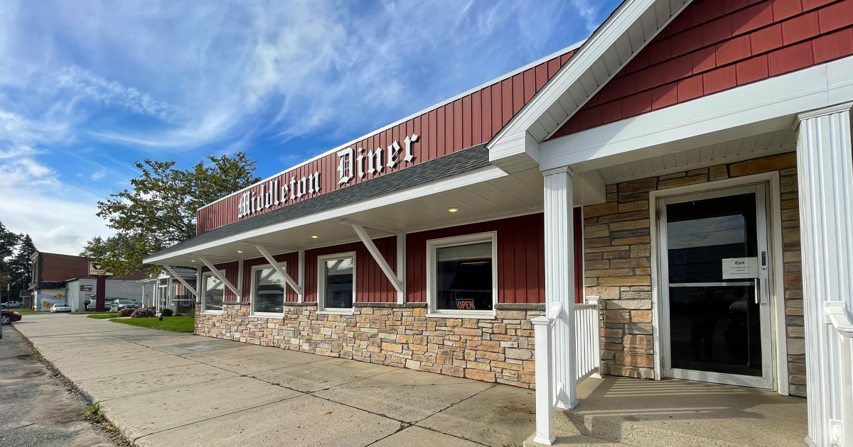 the front view of the middleton diner, a classic american eatery, with its red and white fa&ccedil;ade, stone accents, and welcoming entrance under clear blue skies