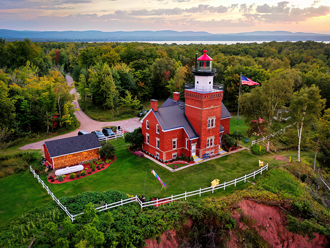 Big Bay's iconic lighthouse stands sentinel against a sunset sky, where Lake Superior meets the horizon in a perfect watercolor blend.
