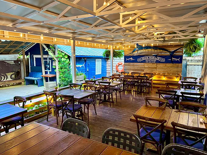 The covered deck at Blue Marlin welcomes diners with rustic wooden tables and a nautical atmosphere that whispers, "Slow down, you're on island time now."