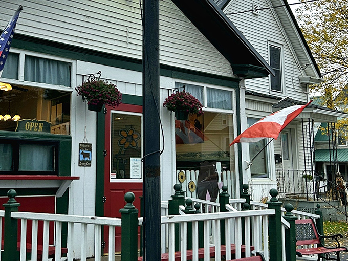 The charming exterior of The Brown Cow welcomes hungry visitors with its classic white clapboard, red door, and picket fence.