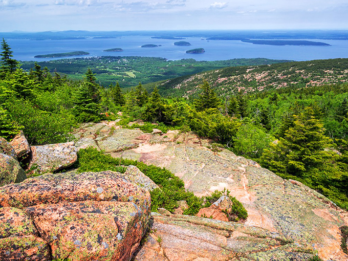The Cadillac North Ridge Trail sign stands weathered but proud, like a sentinel guarding the gateway to Maine's granite paradise.
