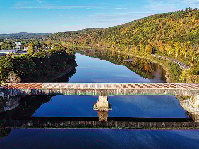 Autumn's golden touch transforms the Cornish-Windsor Bridge into a painting come to life, reflecting perfectly in the Connecticut River below.