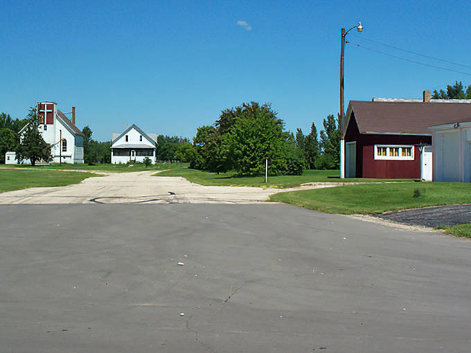 The iconic Dorothy homes stand sentinel against a brilliant blue Minnesota sky, welcoming visitors to this time-capsule of rural Americana.