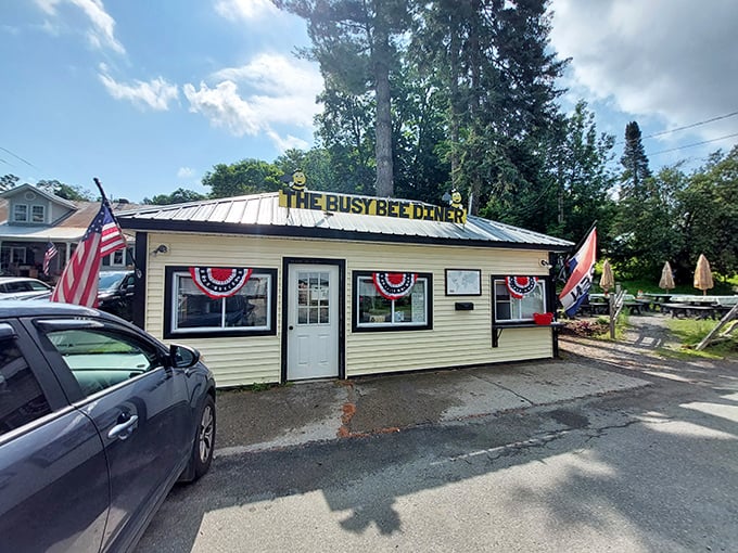 The cheerful yellow exterior of Busy Bee Diner stands proudly in Wilmington, complete with patriotic bunting and that iconic bee signage.