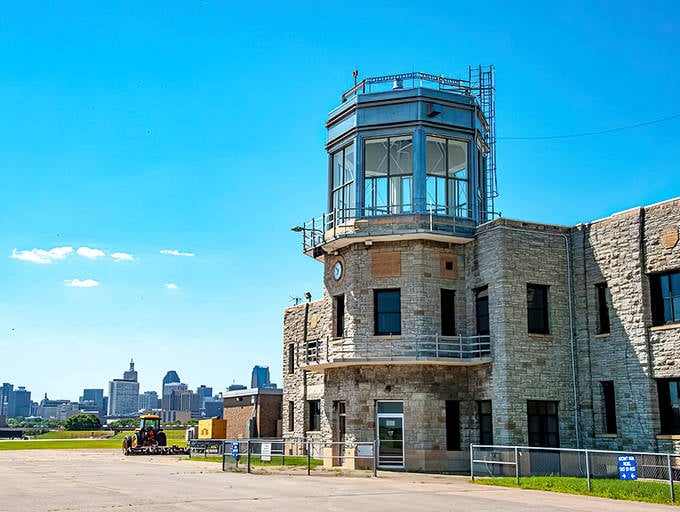 The historic stone terminal building stands proudly against the blue sky, offering diners a glimpse into aviation's golden age.