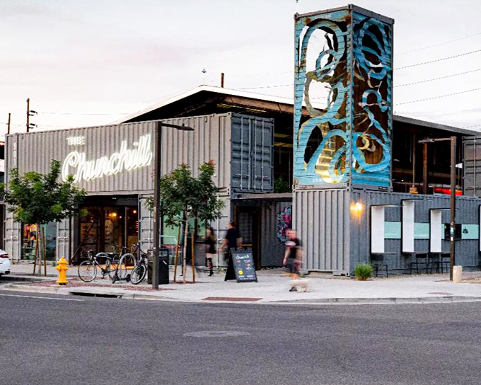 The Churchill's striking exterior combines industrial shipping containers with artistic flair, creating an unmistakable landmark in Phoenix's Roosevelt Row district.