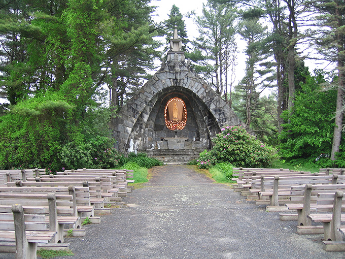 The stone arched entrance to the Grotto of Our Lady of Lourdes creates a portal between worlds, inviting visitors into a space of quiet contemplation.
