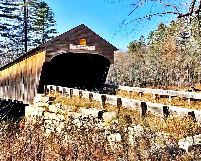 Hemlock Bridge stands proudly against a brilliant blue Maine sky, its weathered wooden frame telling stories of 166 years gone by.