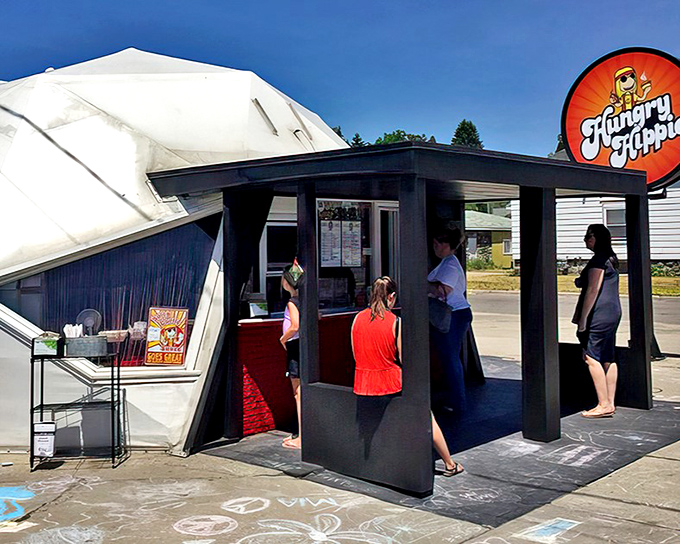 The iconic Hungry Hippie storefront stands out with its distinctive shape and vibrant signage, a groovy beacon for hungry travelers seeking something beyond ordinary fast food.