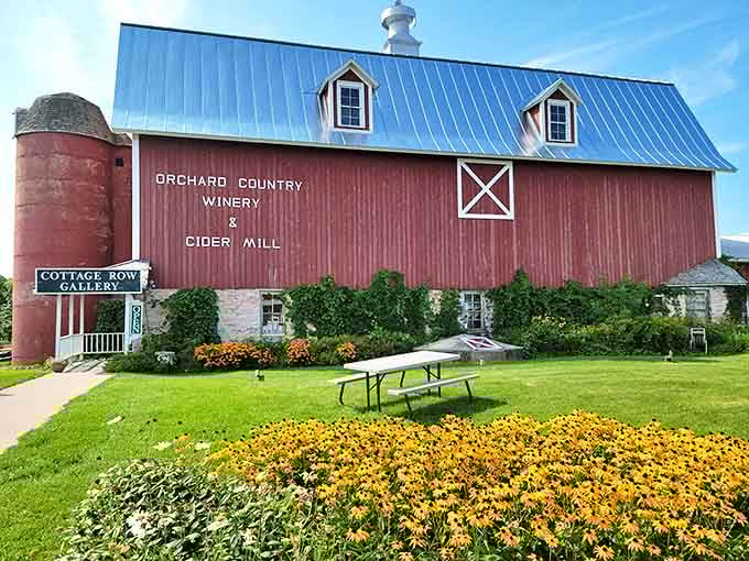 The classic red barn with blue metal roof stands proudly among blooming flowers &ndash; Door County's version of a welcome mat.