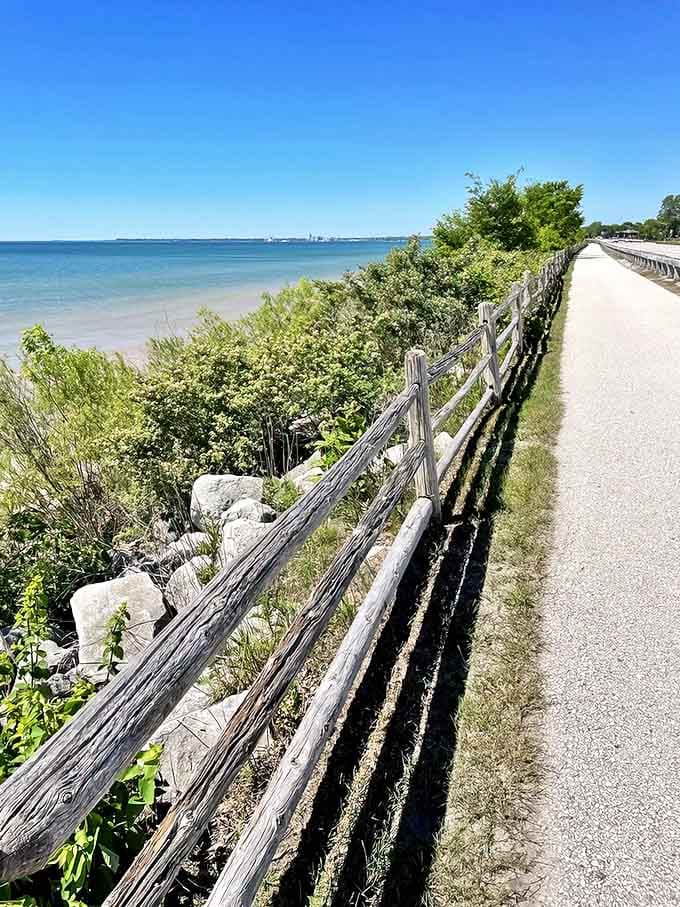 Rustic wooden fencing guides the way along Mariners Trail, where Lake Michigan plays peekaboo through shoreline greenery.