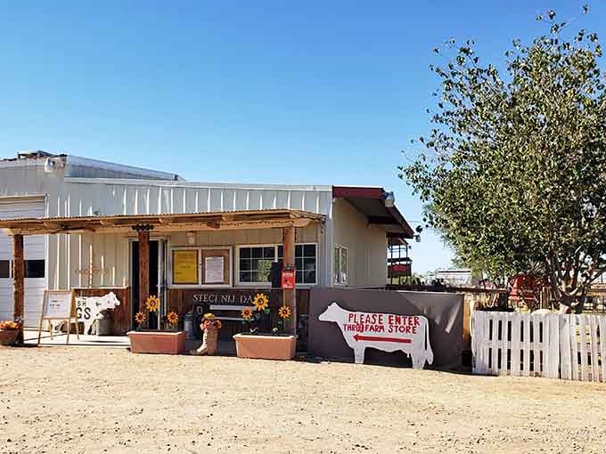 The farm store entrance welcomes visitors with rustic charm and a sign that promises fresh dairy delights just beyond those doors.