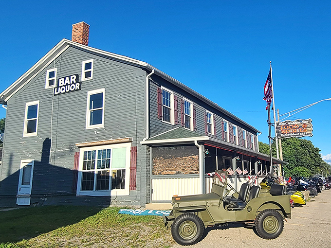The New Hudson Inn stands proudly since 1831, its sage-green clapboard exterior and vintage military Jeep hinting at stories waiting inside.