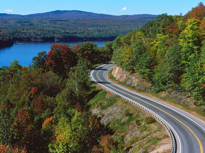 The winding ribbon of asphalt hugs the shoreline of Rangeley Lake, where every curve reveals another postcard-worthy vista that demands a photo stop.