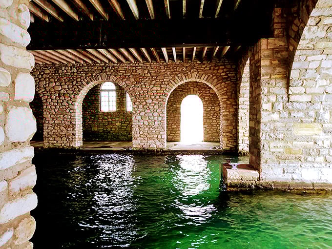 Stone arches frame emerald waters inside the boathouse, creating a magical grotto where history and nature dance in perfect harmony.