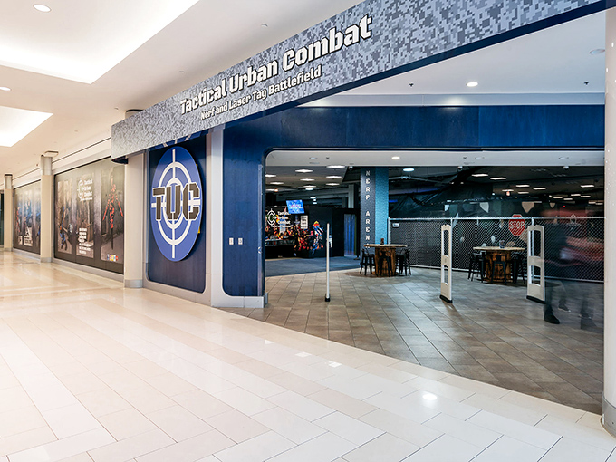 The sleek, modern entrance to Tactical Urban Combat beckons mall-goers with its distinctive blue logo and promise of high-tech adventure.