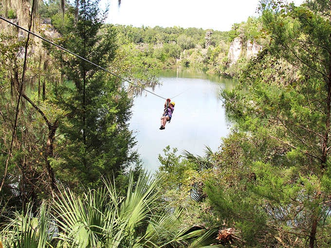 Soaring through the air, a zipline adventurer experiences Florida's longest ride across the emerald waters of this former limestone quarry.