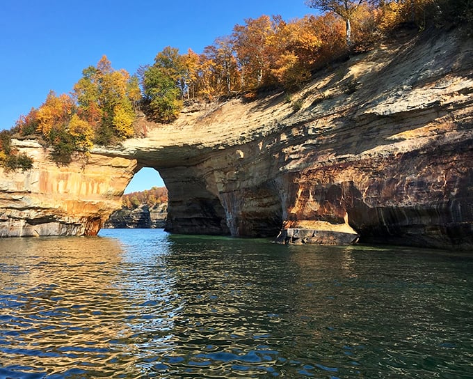 Nature's perfect arch frames the Caribbean-blue waters of Lake Superior, proving Michigan can deliver postcard moments that make tropical islands jealous.
