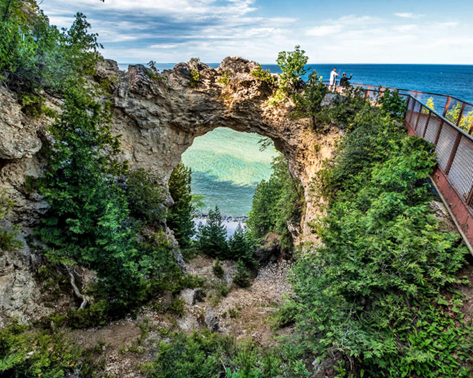 Nature's perfect picture frame on Mackinac Island, where 146 feet of limestone artistry captures Lake Huron's impossible blues. Worth every step of the climb!