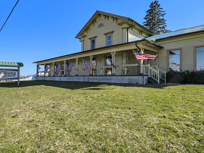 The charming yellow exterior of The Grill House welcomes visitors with its wide porch and American flags &ndash; a slice of Norman Rockwell's America in Michigan.