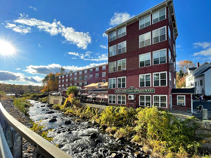 The iconic red-shingled former shoe factory now houses culinary treasures instead of leather goods, perched perfectly alongside the rushing Wilton Stream.