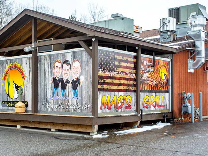 Mac's Grill exterior welcomes hungry visitors with rustic charm and patriotic flair &ndash; a wooden cabin of culinary delights waiting to be discovered.