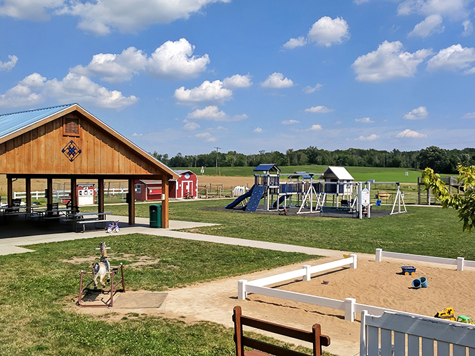 The rustic charm of Moo-Ville's exterior welcomes visitors with its barn-style architecture and playground, promising both treats and fun under Michigan's big sky.