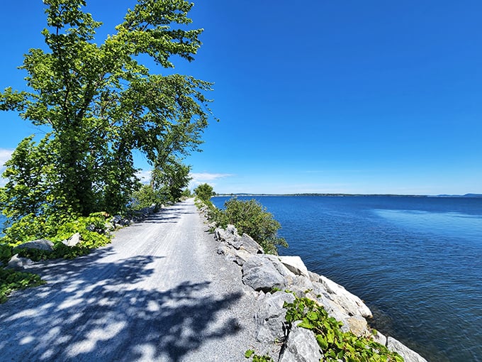 A ribbon of crushed stone stretching across Lake Champlain, where every step feels like walking on water's edge.