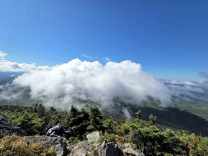 Clouds embrace the mountain like a fluffy scarf, playing hide-and-seek with hikers brave enough to reach Camel's Hump's summit.