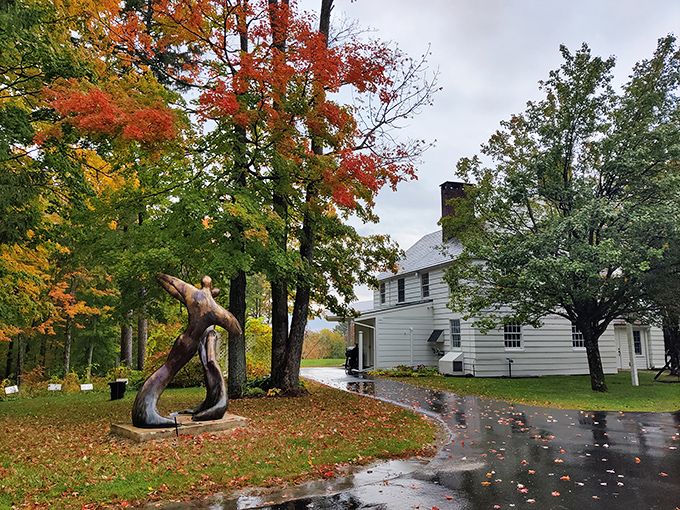 Fall foliage frames the historic white buildings of SVAC, where a striking modern sculpture stands sentinel among autumn leaves.